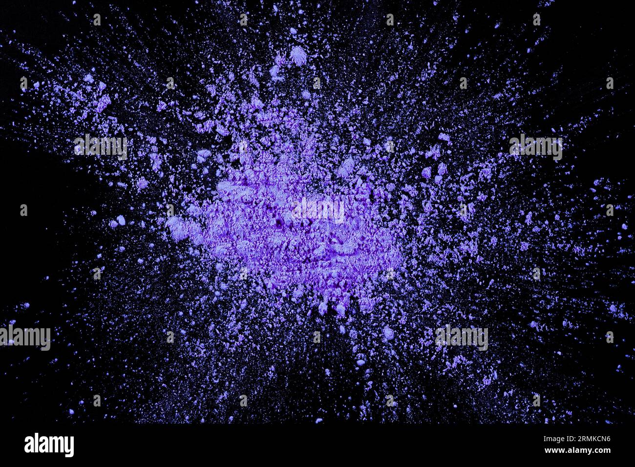 Overhead view purple color exploding dark surface Stock Photo - Alamy