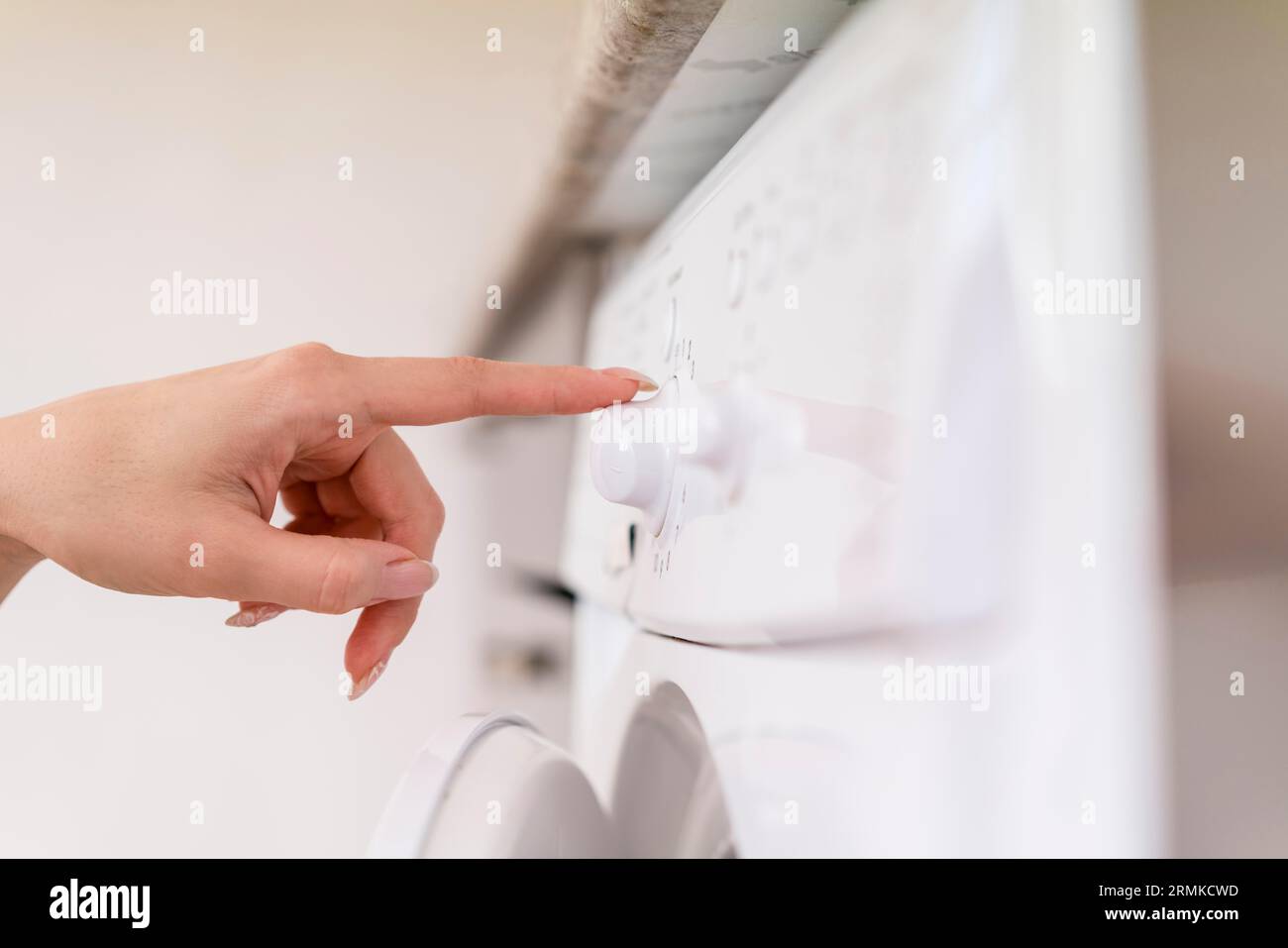 Side view hand touching washing machine Stock Photo - Alamy