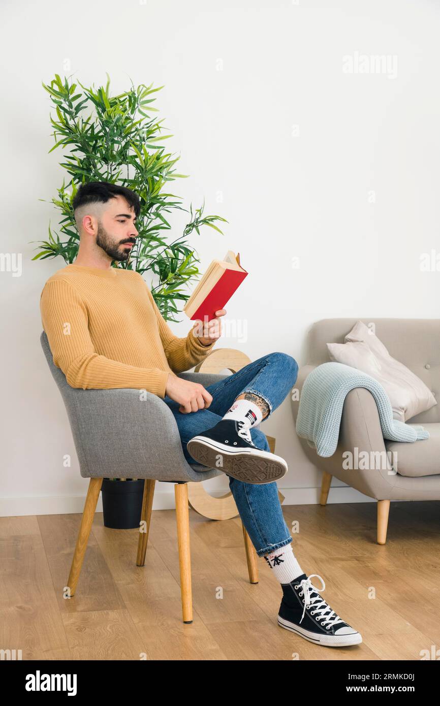 Side view handsome serious young man sitting chair reading book Stock ...