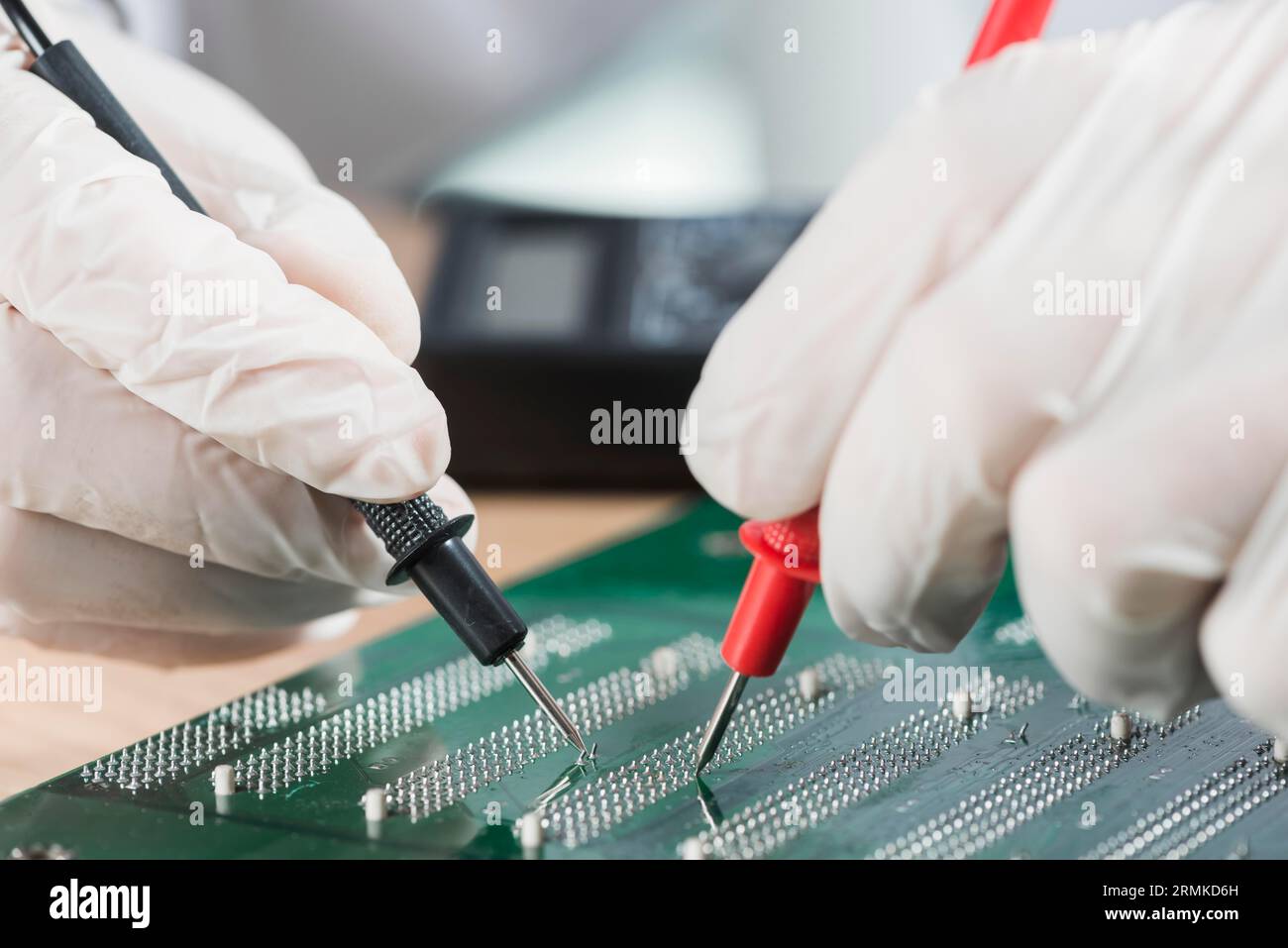 Technician wearing gloves examining computer circuit board with digital ...