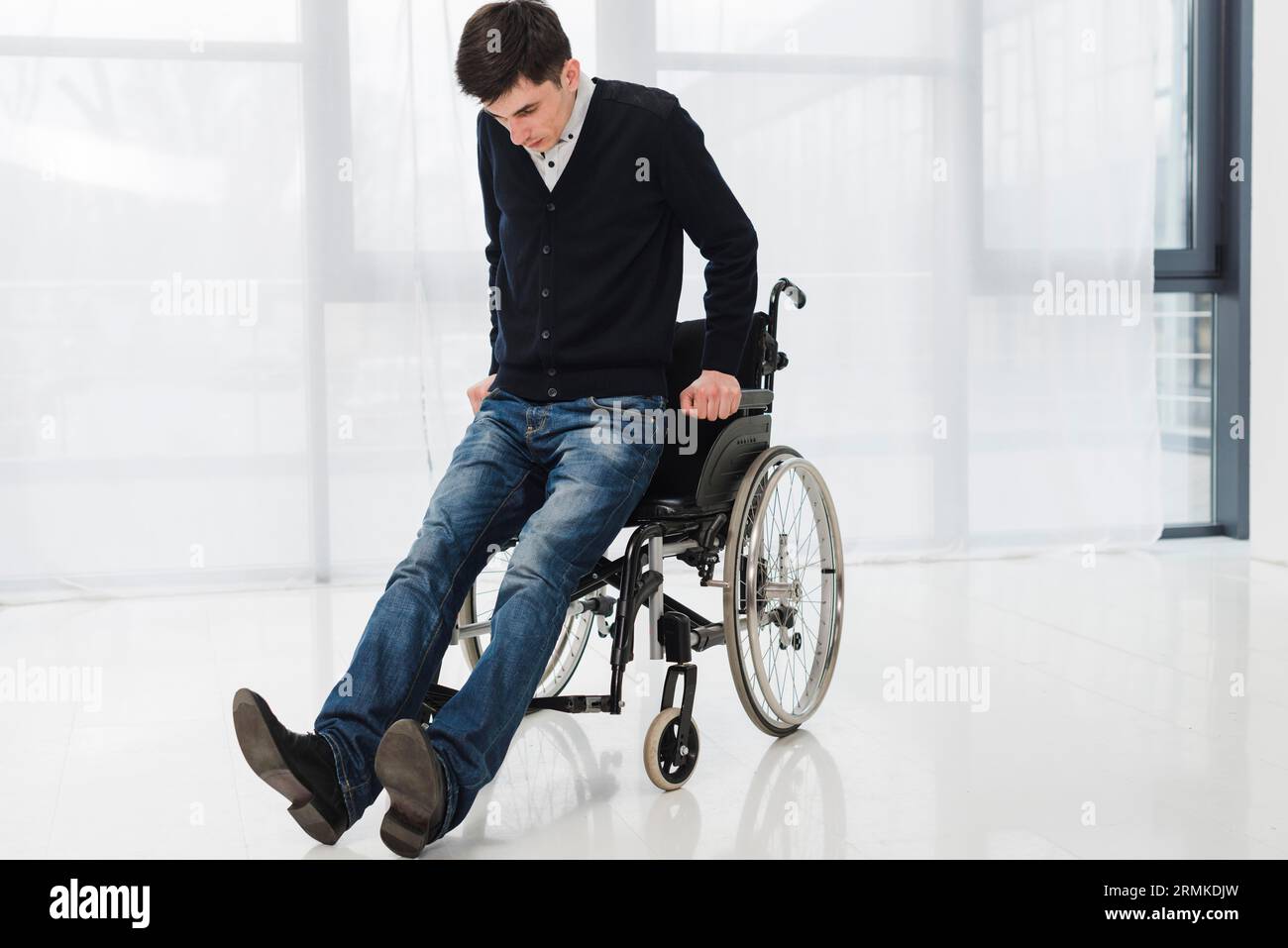 Young man trying get from wheelchair Stock Photo - Alamy Young man trying get from wheelchair Stock Photo - Alamy