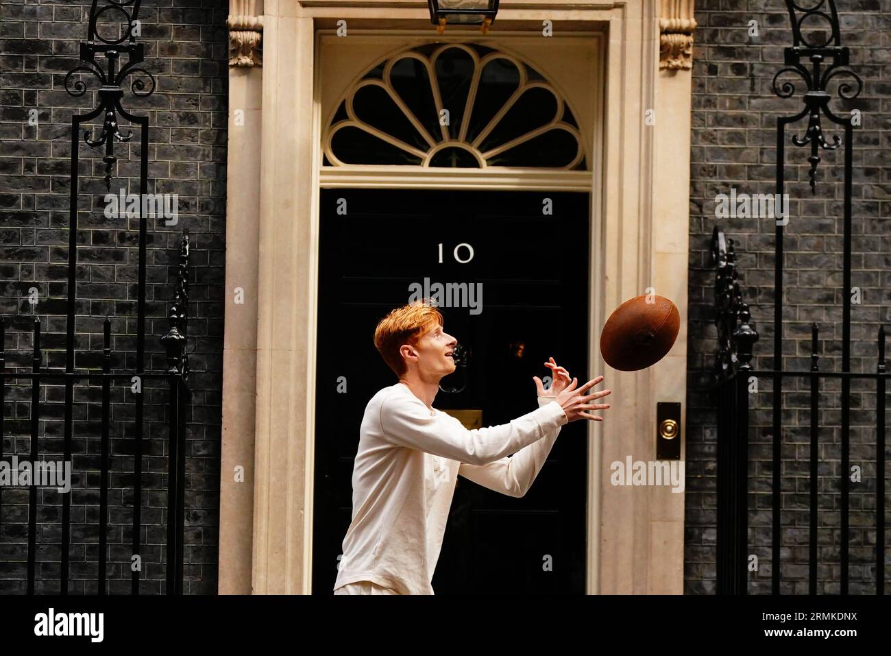 Jake Barraclough tosses a rugby ball outside 10 Downing Street, London ...