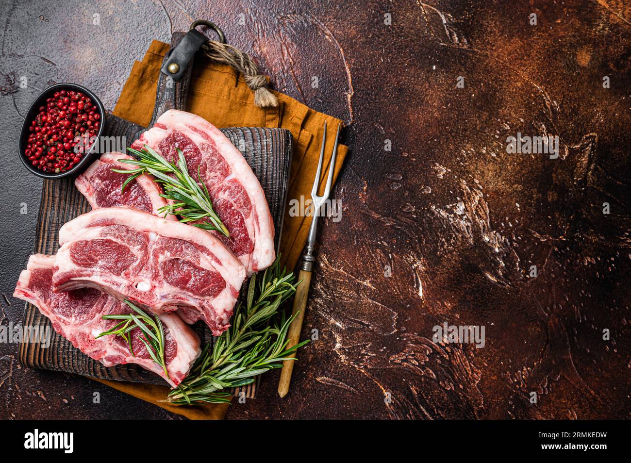Raw fresh saddle of lamb mutton with herbs and spices on butcher board ...