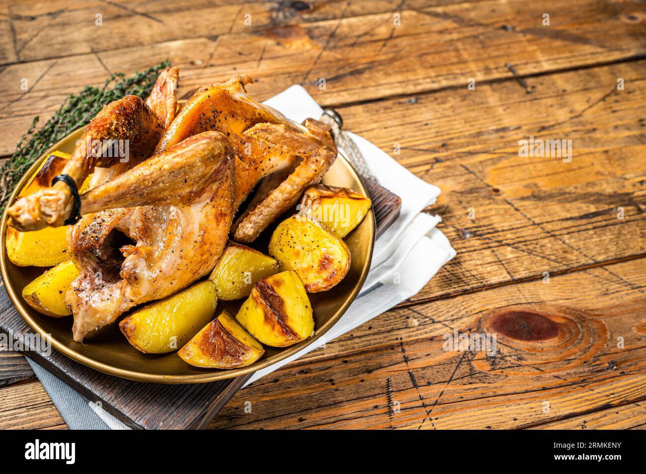 Roasted guinea fowl with herbs and potato, cooked farm eco bird. Wooden ...