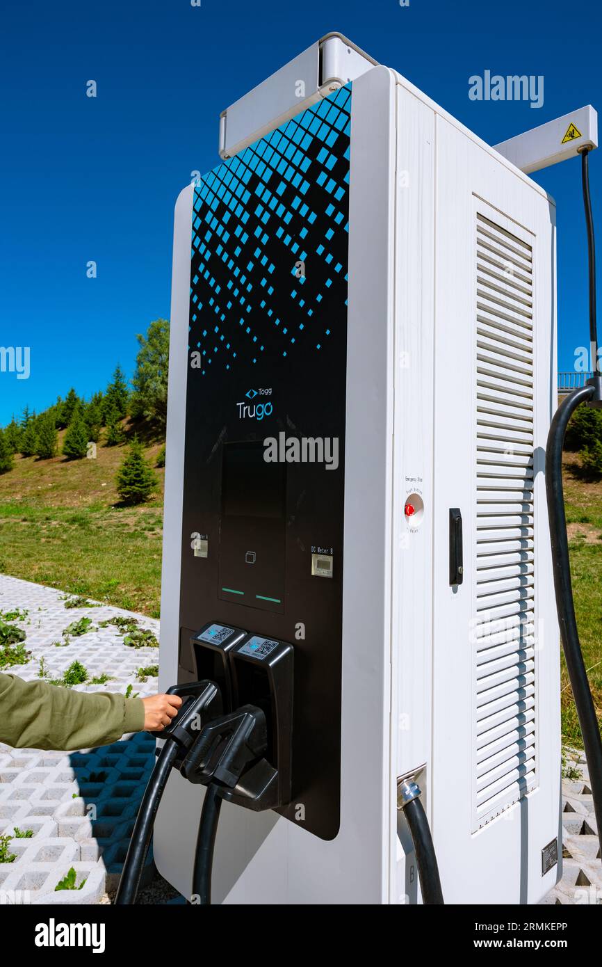 TOGG Trugo EV charger. Woman holding a car charging plug. Turkish ...