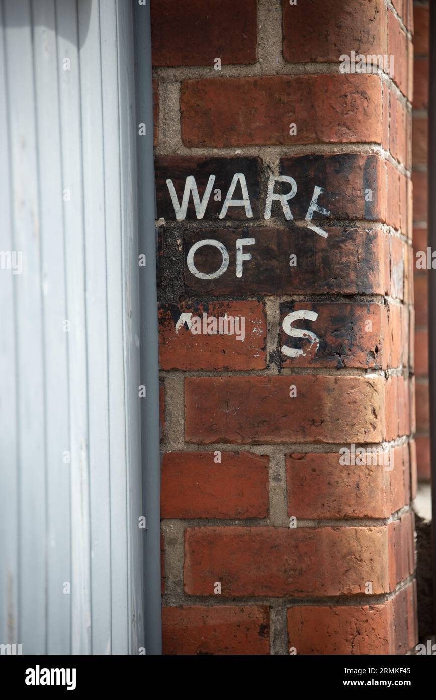 An old and partially covered and faded Beware of Cars painted sign on ...