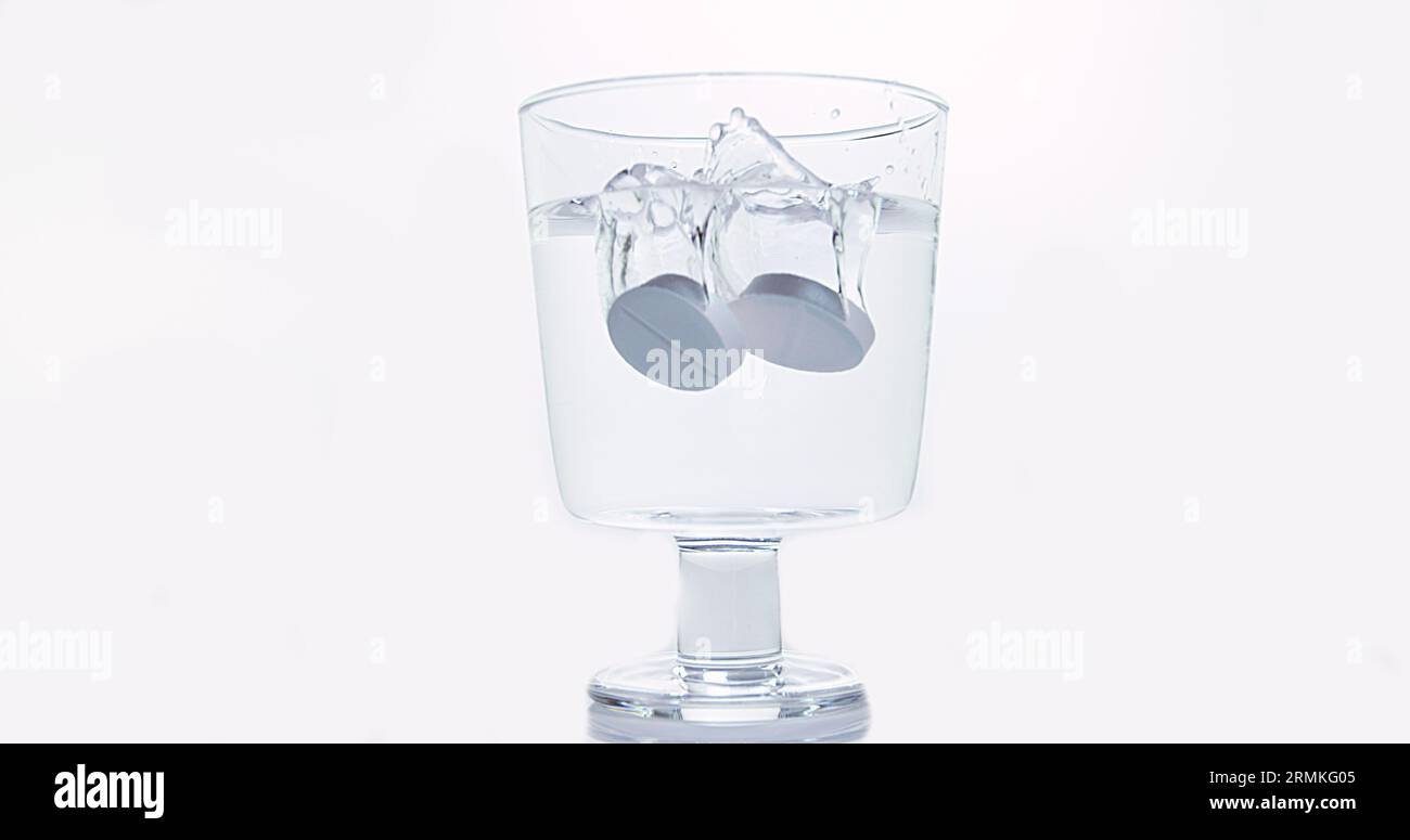 Tablets Falling and Dissolving into a Glass of Water against White ...