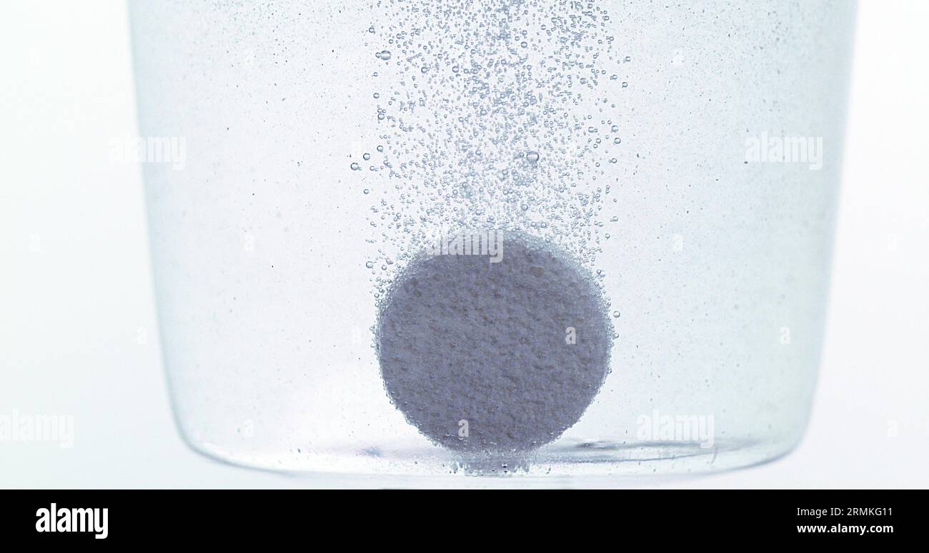 Tablets Falling and Dissolving into a Glass of Water against White ...