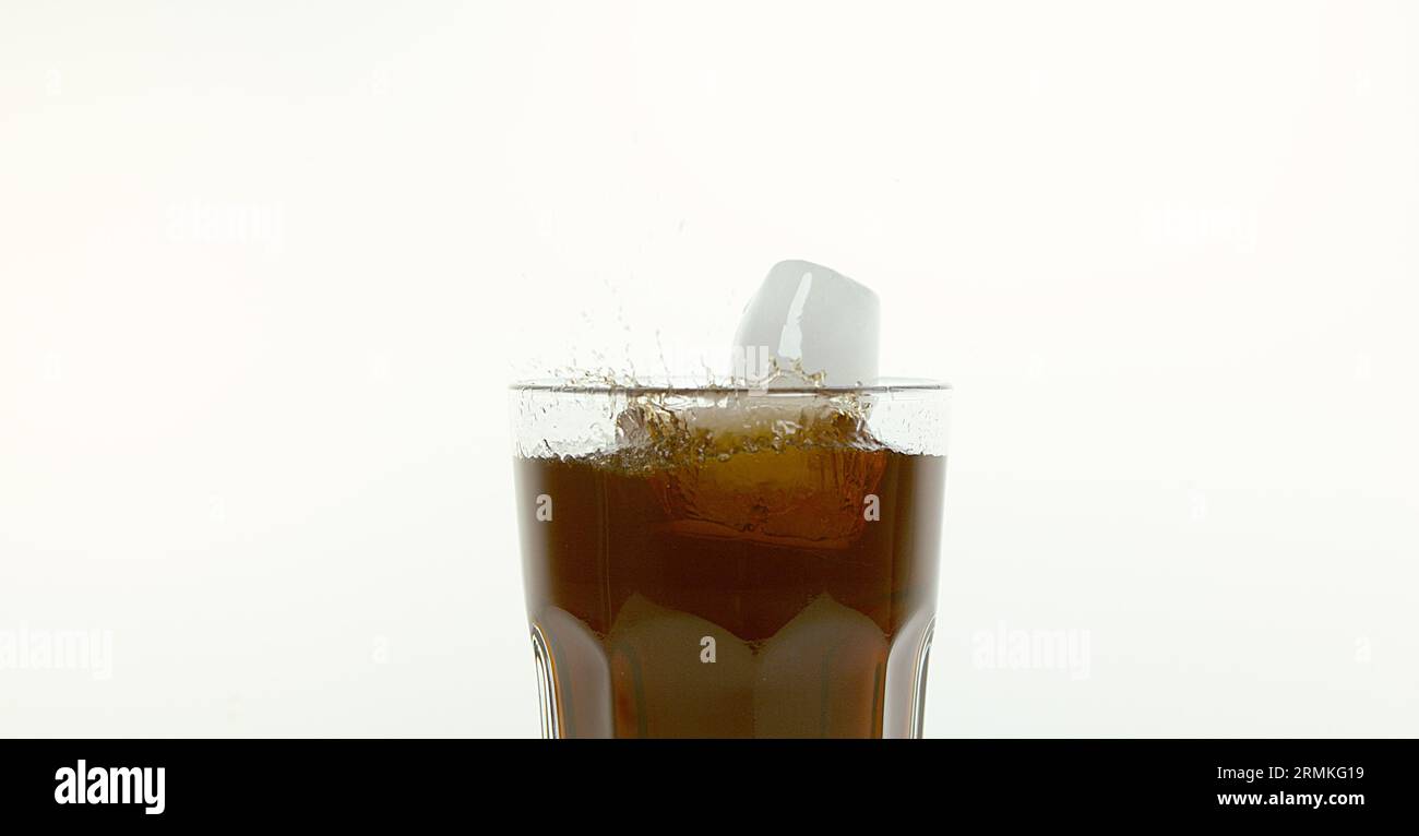 Ice Cubes Falling into Glass of Coke against White Background Stock ...