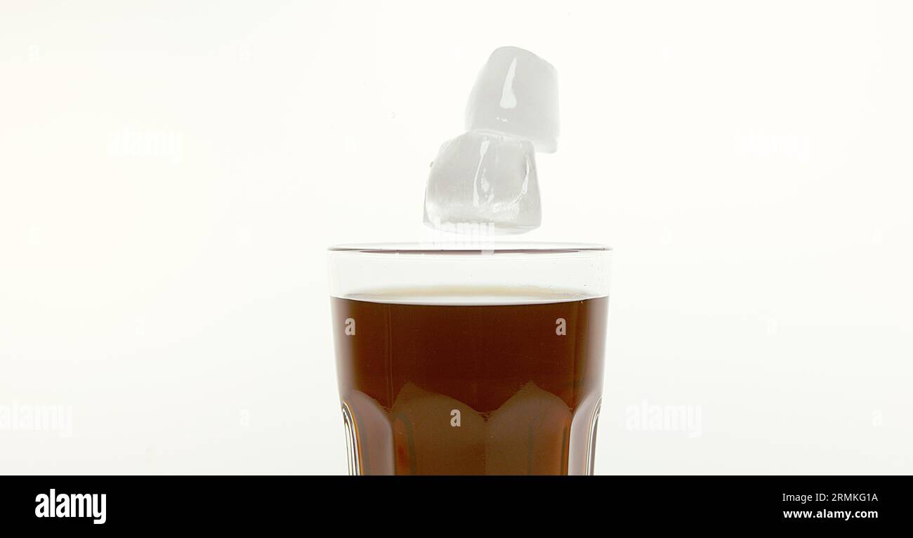 Ice Cubes Falling into Glass of Coke against White Background Stock ...