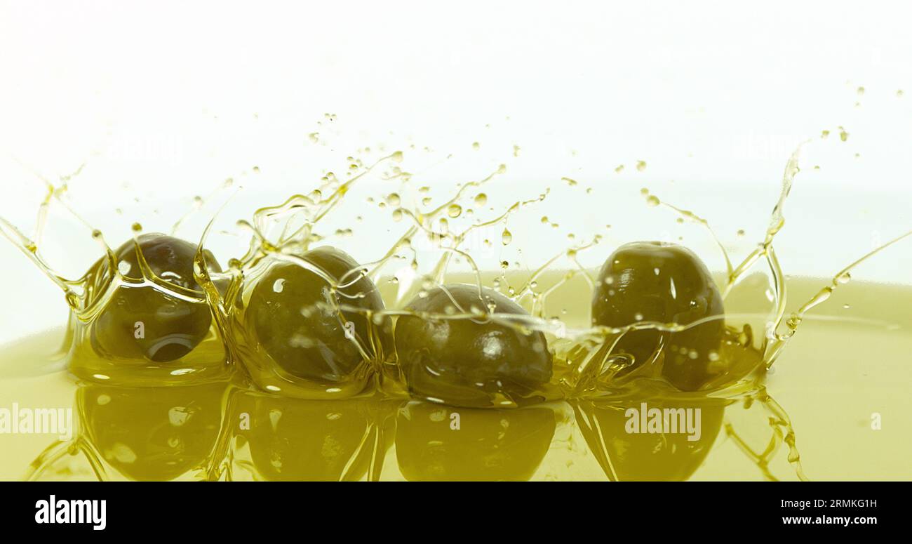 Olives Falling into Olive Oil against White Background Stock Photo - Alamy