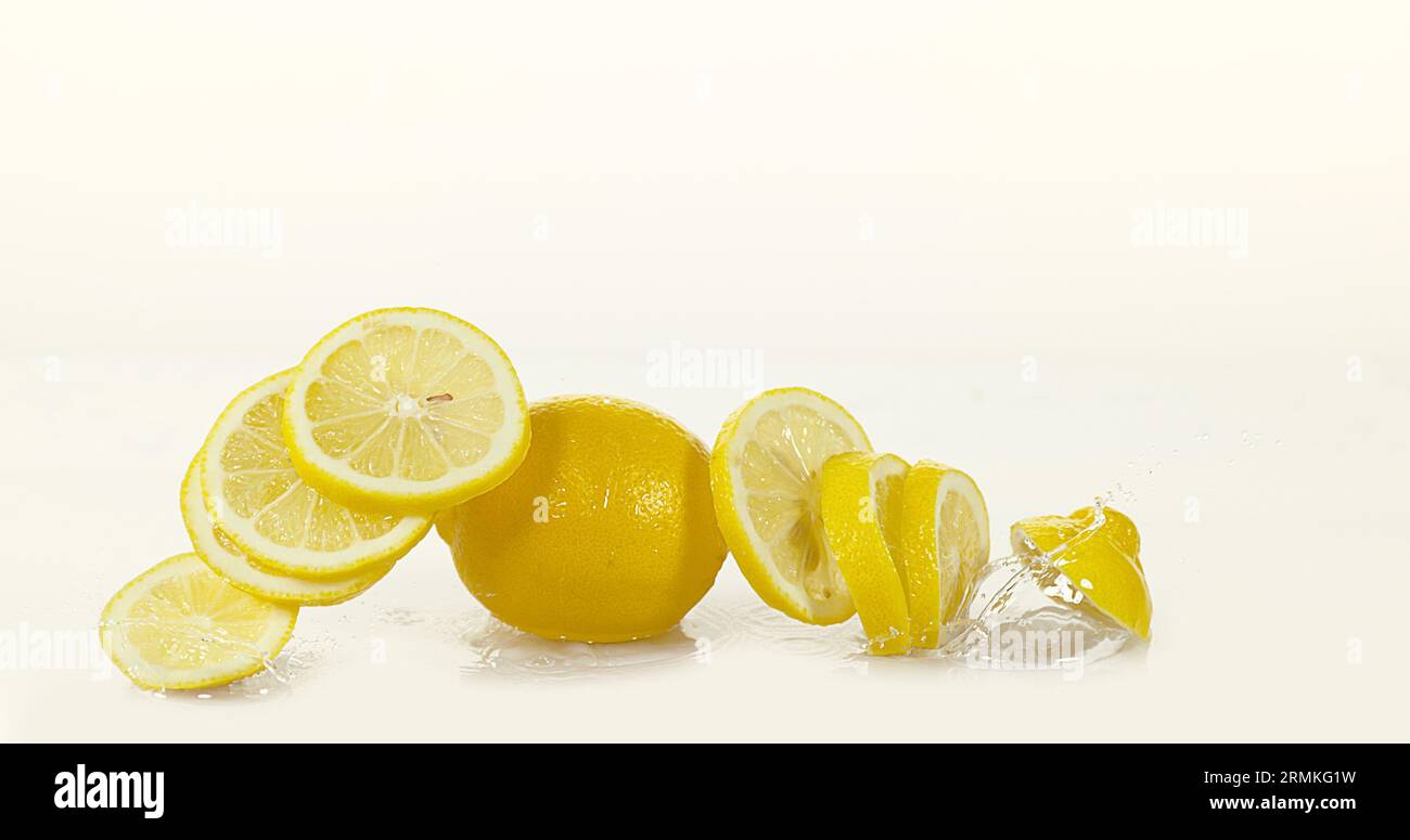 Yellow Lemons, citrus limonum, Fruits Rolling on Water and splashing ...