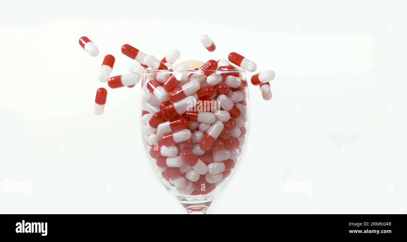 Capsules Falling into a Glass against White Background Stock Photo - Alamy
