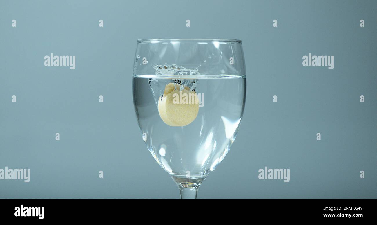 Tablets Falling and Dissolving into a Glass of Water against White ...