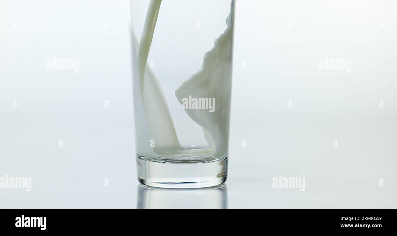 Milk being poured into Glass against White Background Stock Photo - Alamy