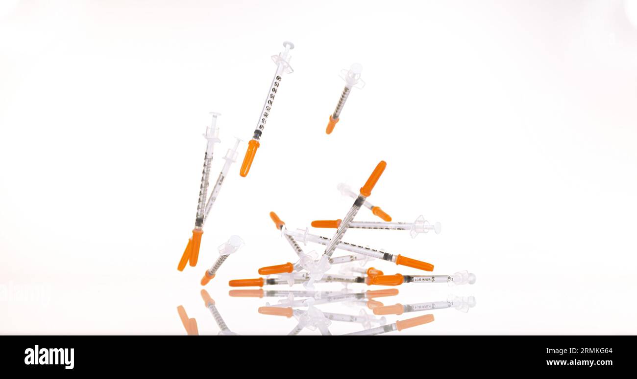 Syringes Falling against White Background Stock Photo - Alamy