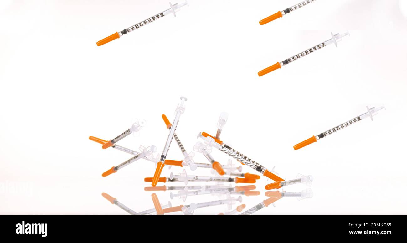 Syringes Falling against White Background Stock Photo - Alamy