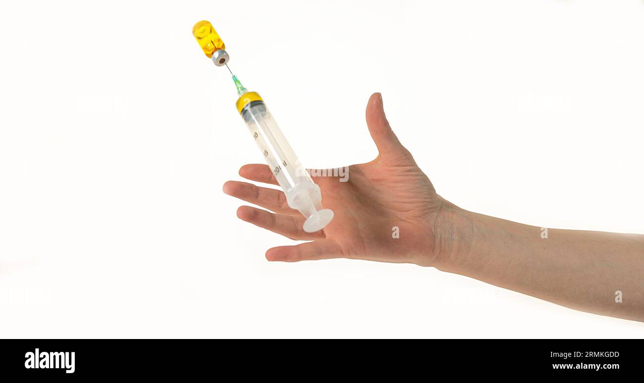 Syringe Falling into Hand against White Background Stock Photo - Alamy