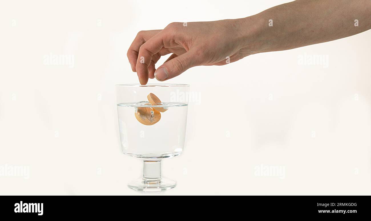 Tablets Falling into a Glass against White Background Stock Photo - Alamy