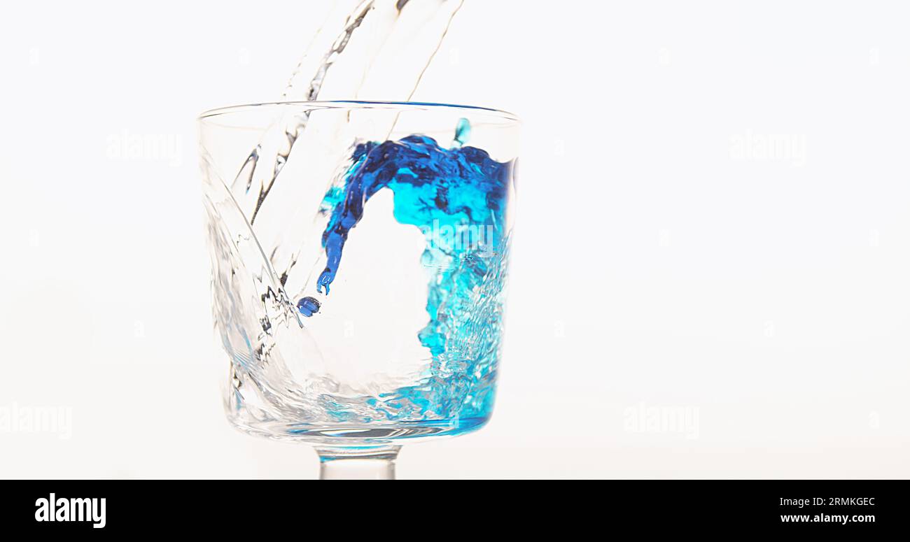 Water being poured into Glass against White Background, blue in the ...