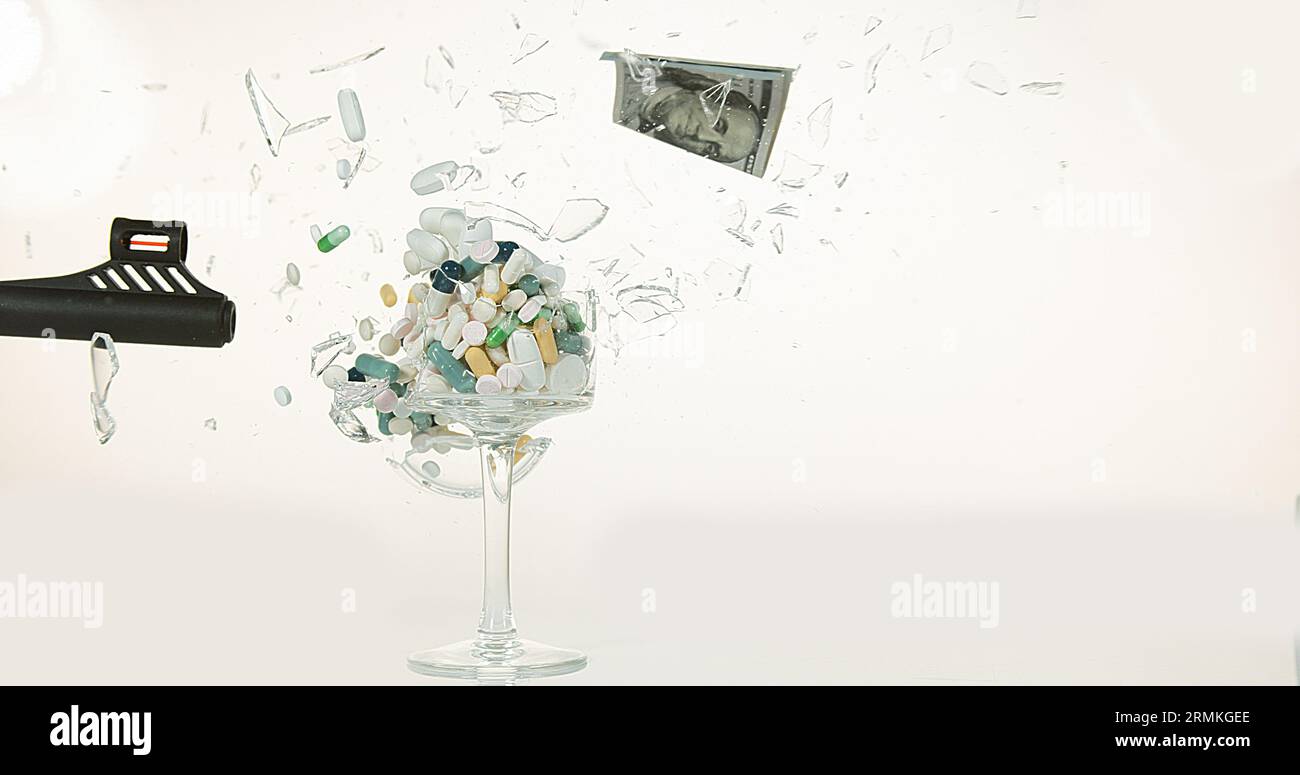 Glass filled with Capsules and Dollars Exploding against White ...