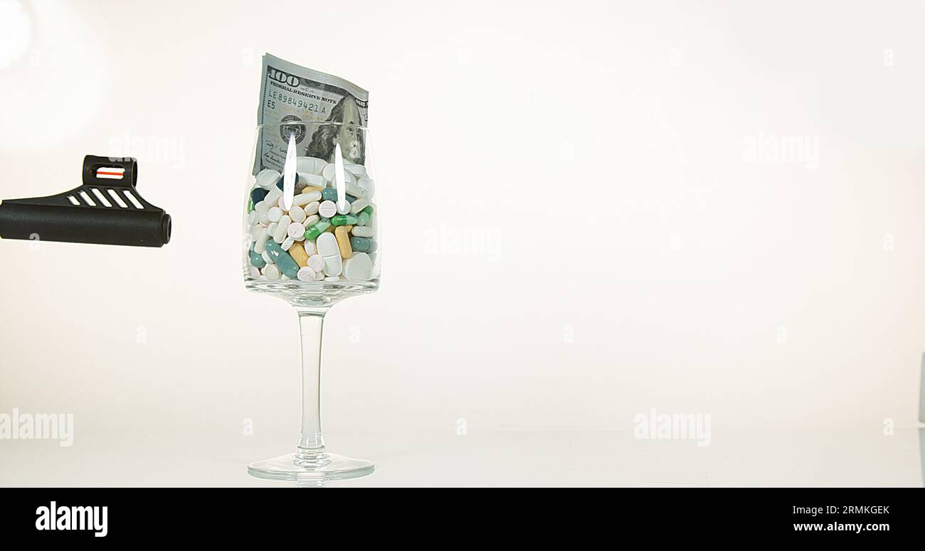 Glass filled with Capsules and Dollars Exploding against White ...