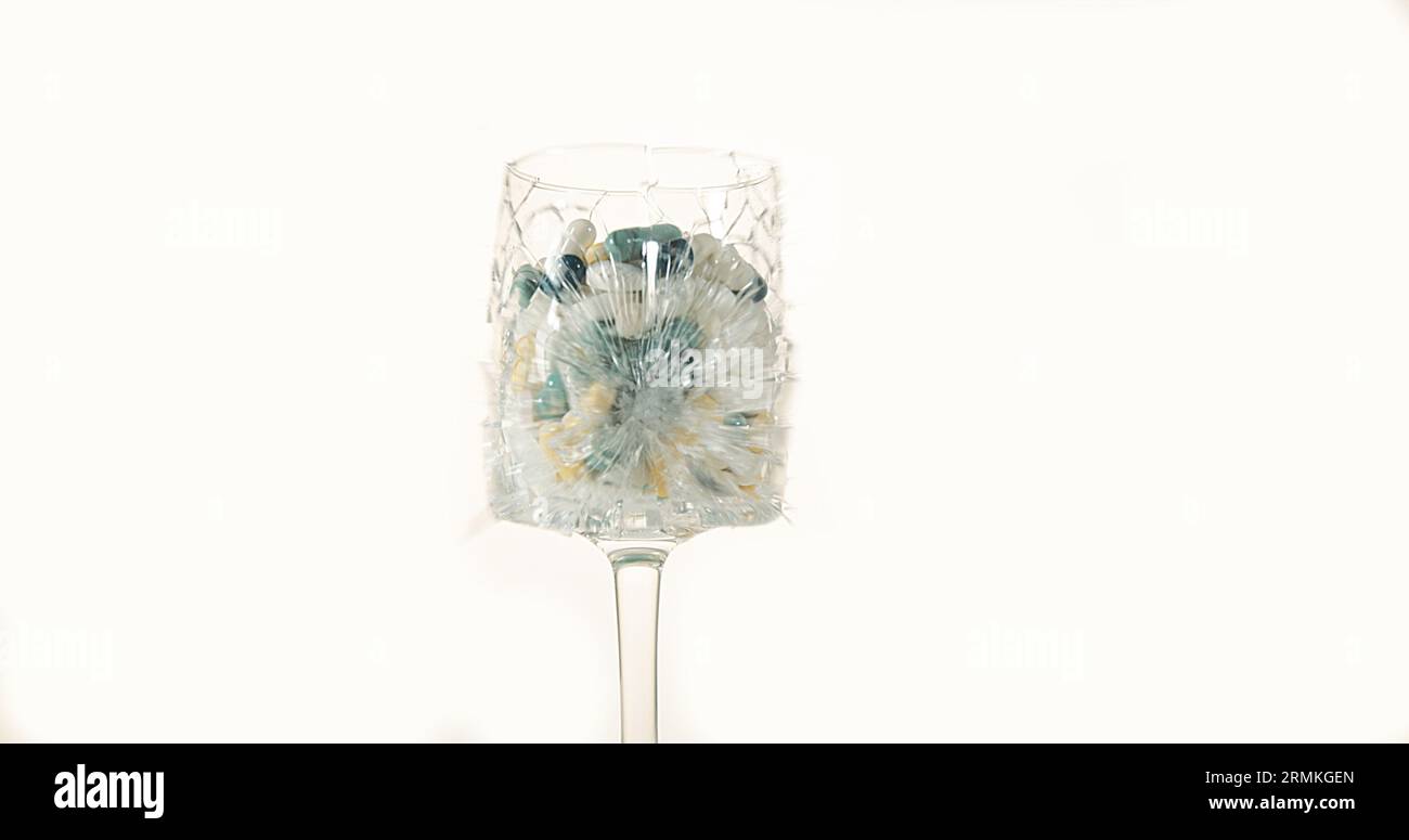 Glass filled with Capsules Exploding against White Background Stock ...