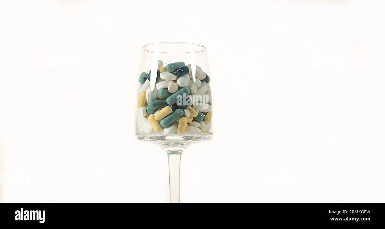 Glass filled with Capsules Exploding against White Background Stock ...
