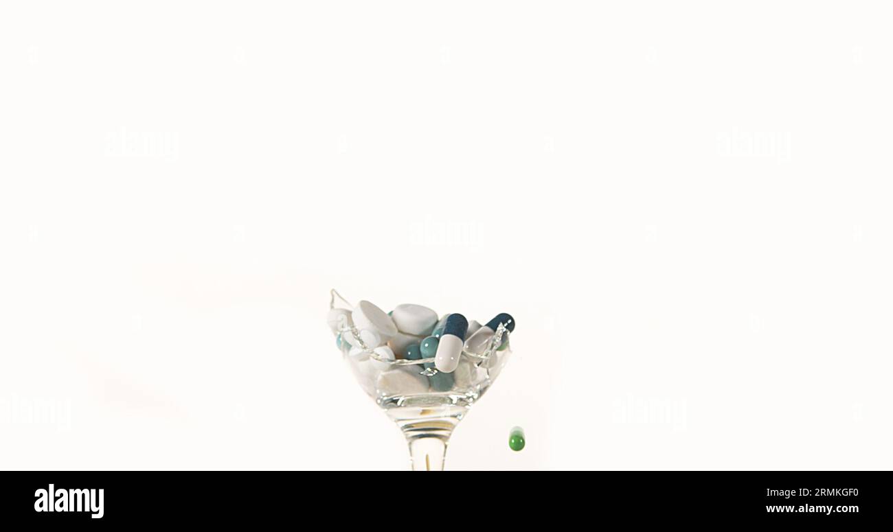 Glass filled with Capsules Exploding against White Background Stock ...