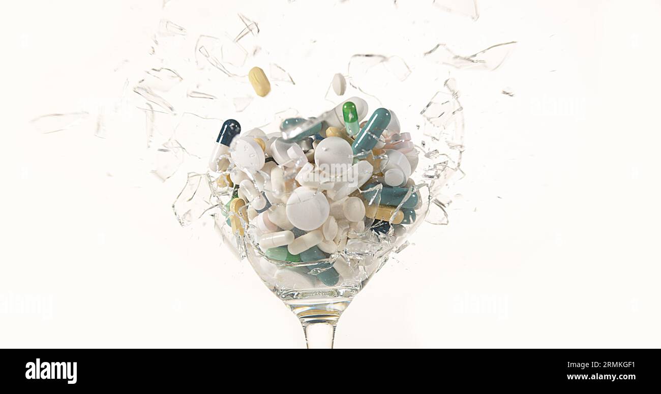 Glass filled with Capsules Exploding against White Background Stock ...