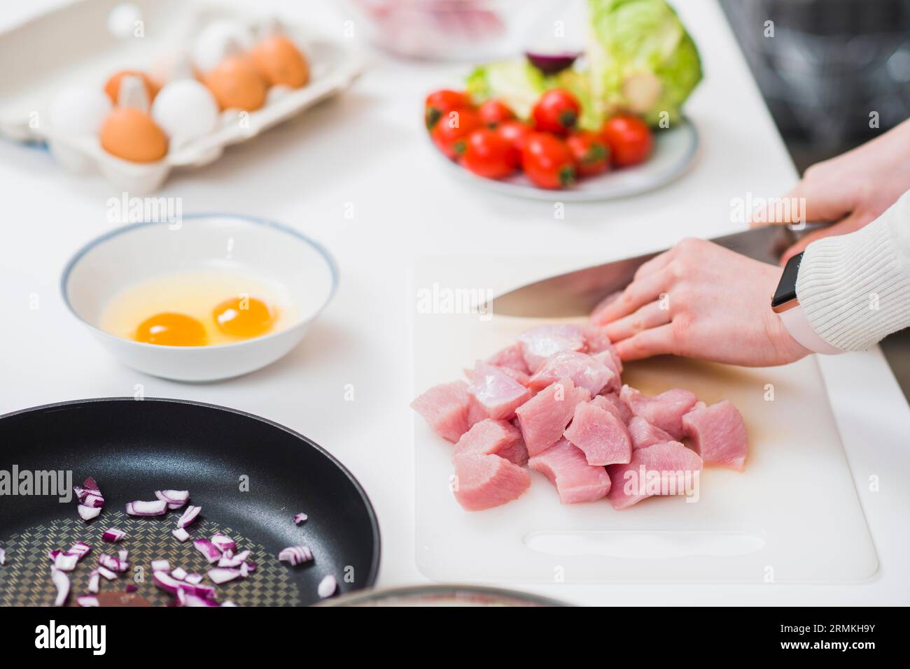 Cooking table with hands cutting meat Stock Photo - Alamy