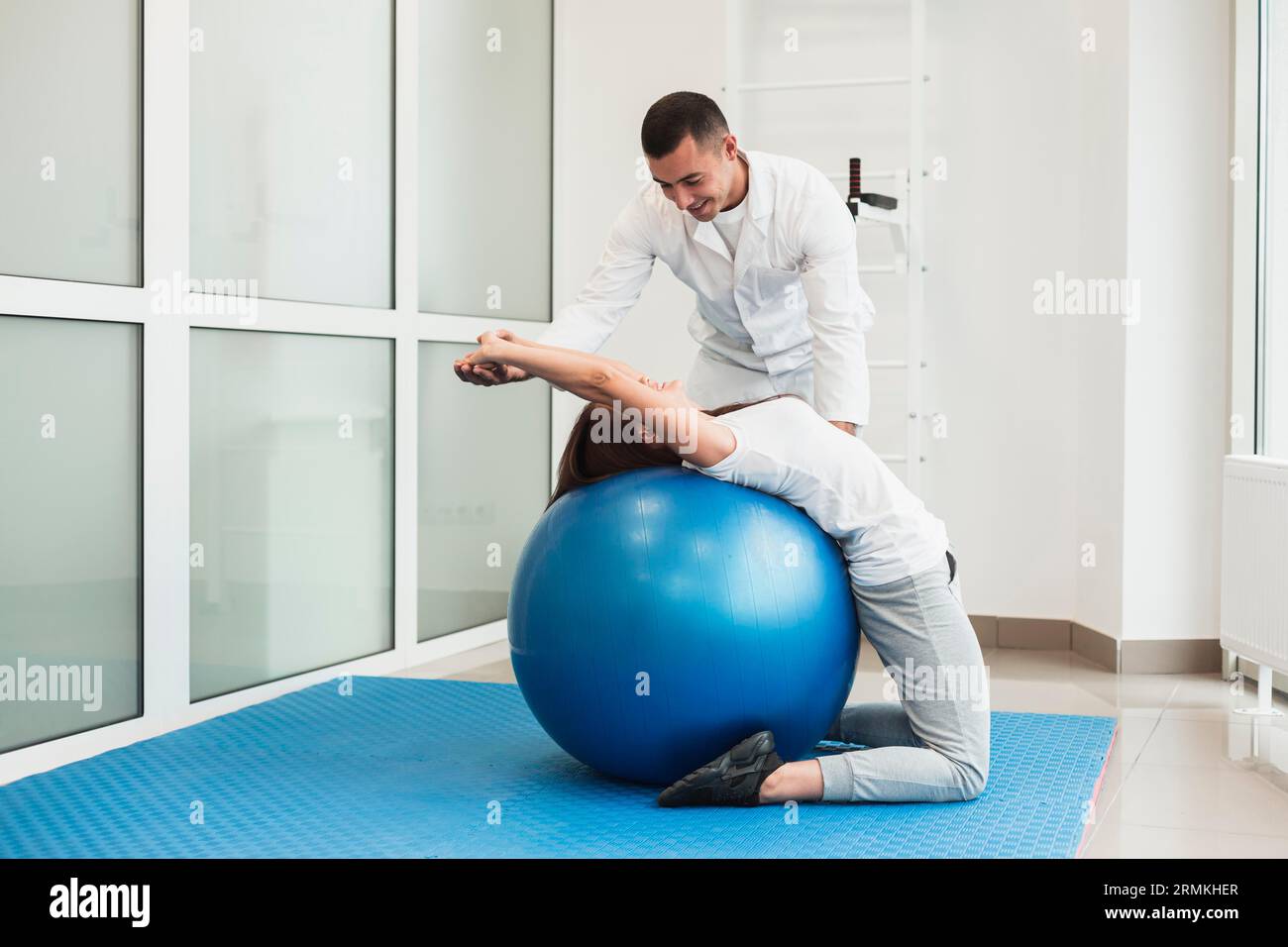 Doctor stretching patient exercise ball Stock Photo - Alamy