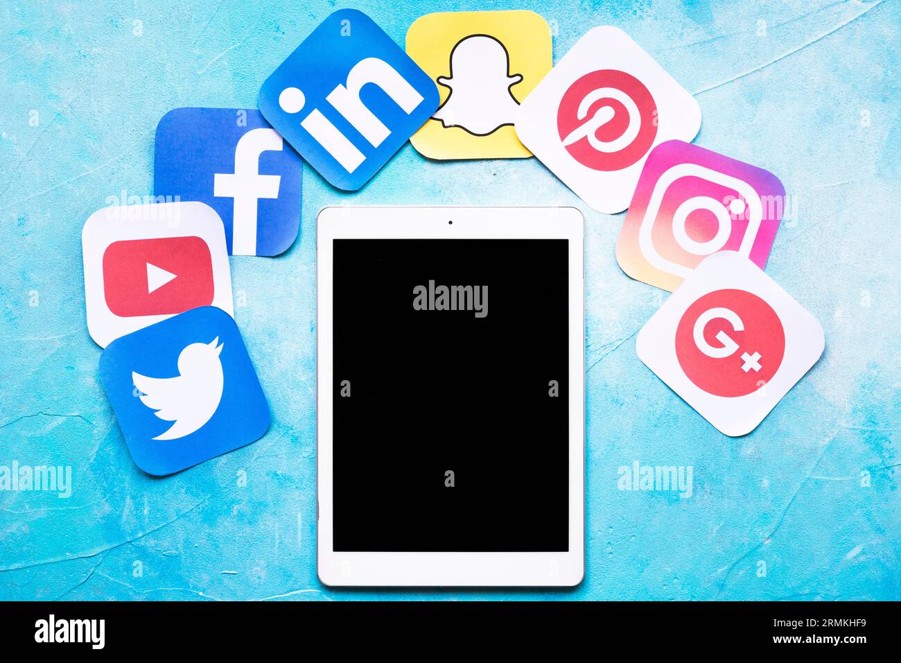 Digital tablet around colorful social media icons painted blue ...