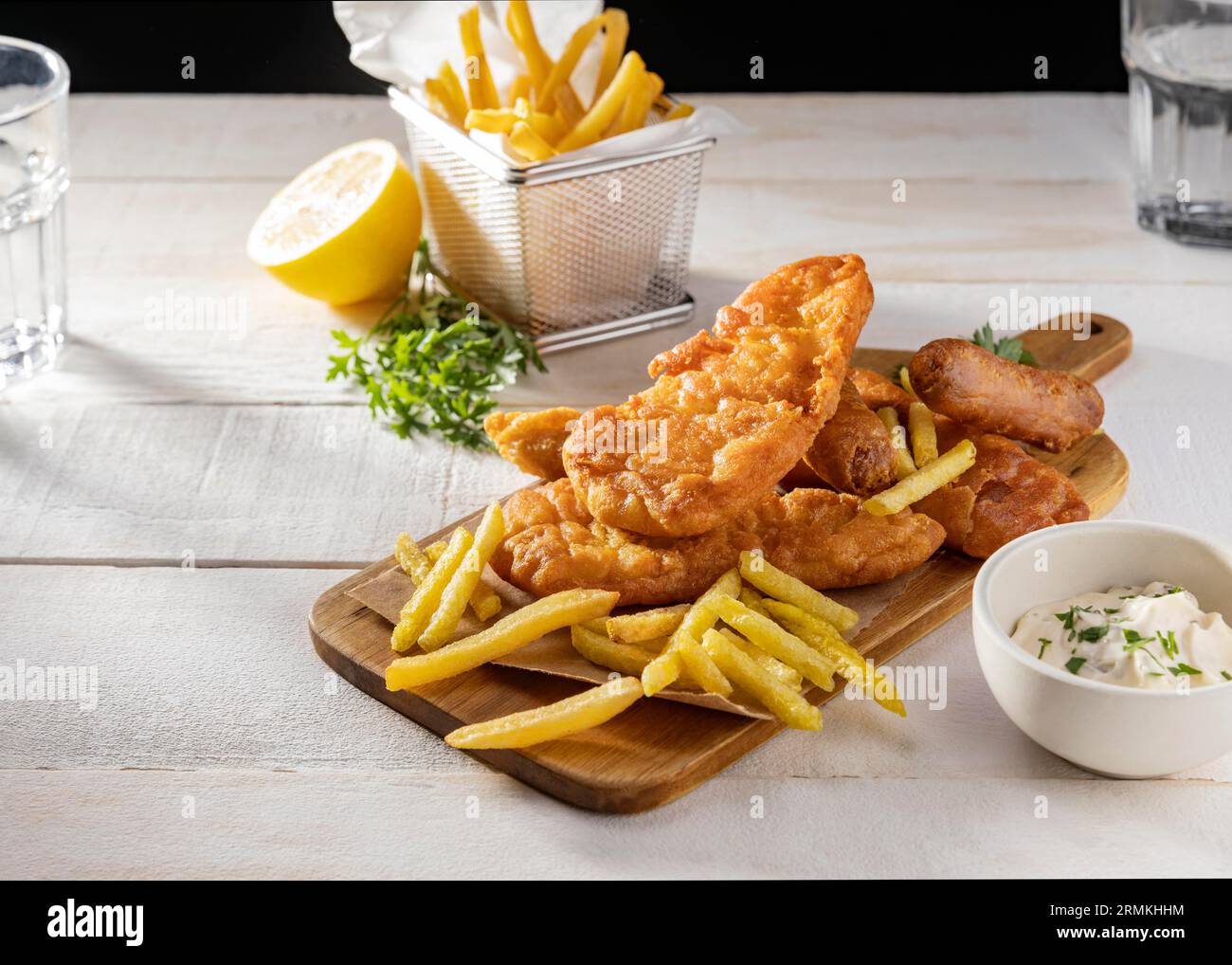 Fish chips chopping board with lemon sauce Stock Photo - Alamy