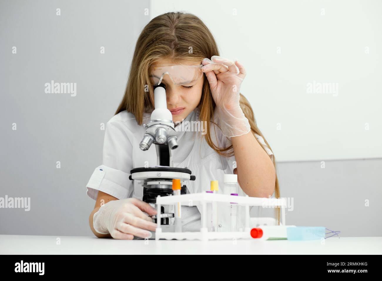 Front view curious young girl scientist using microscope Stock Photo ...