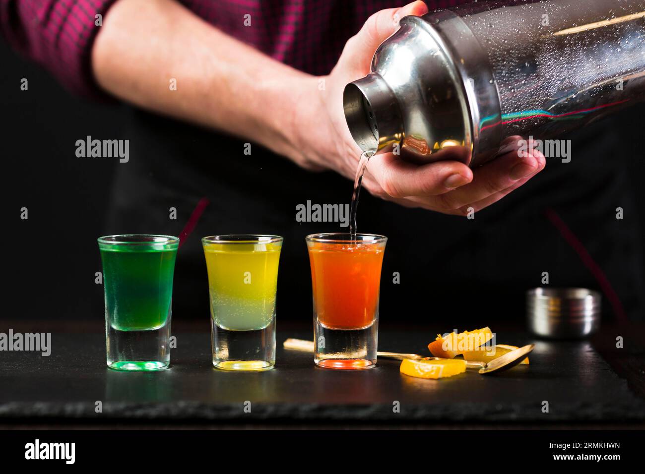 Front view man pouring cocktail shot glasses Stock Photo - Alamy