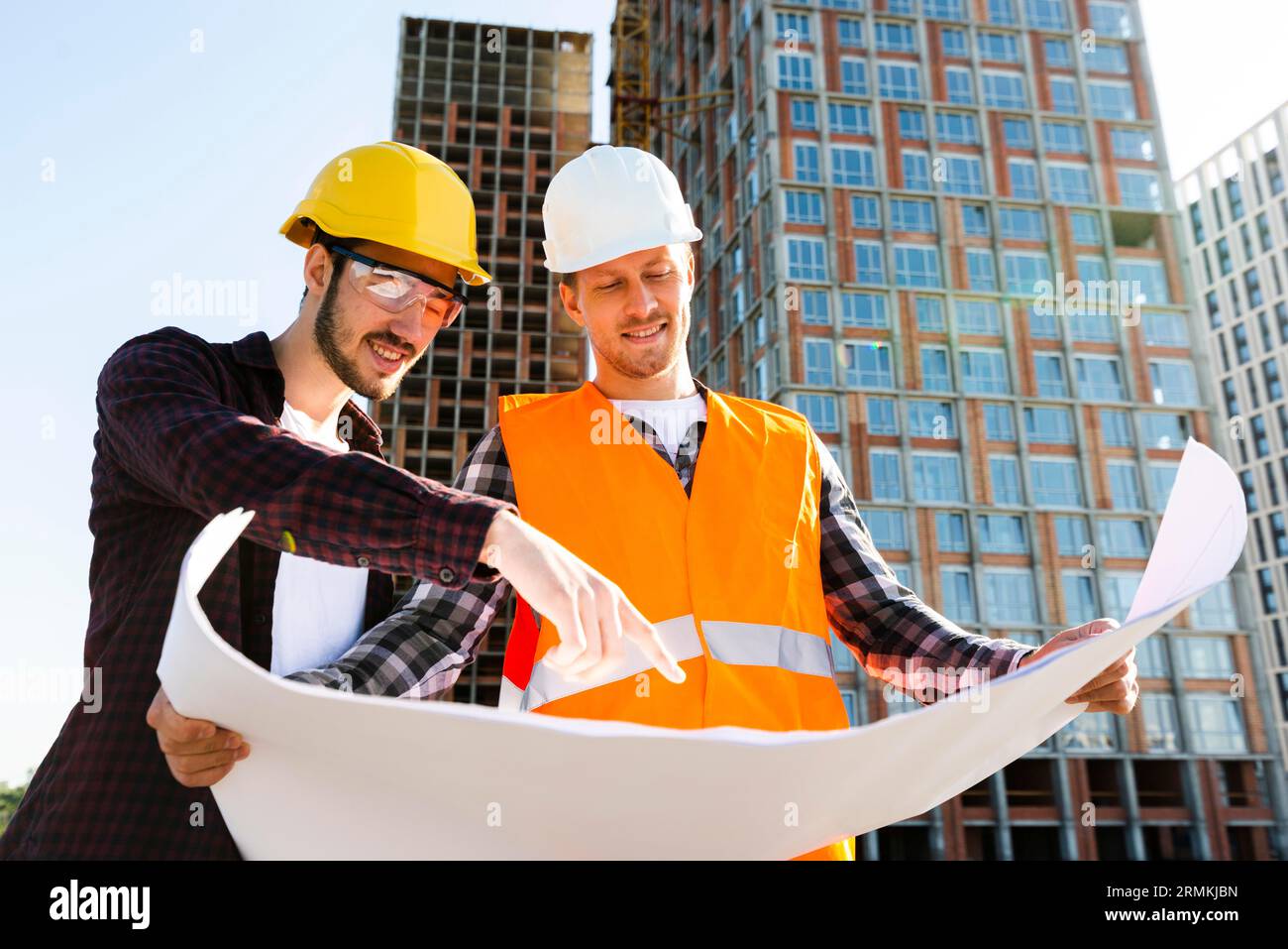 Medium shot low angle view engineer architect supervising construction ...