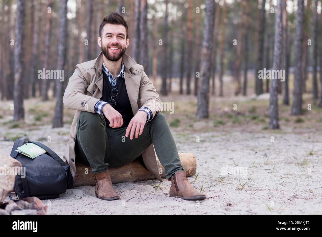 Portrait smiling male traveler sitting beach with his backpack Stock ...