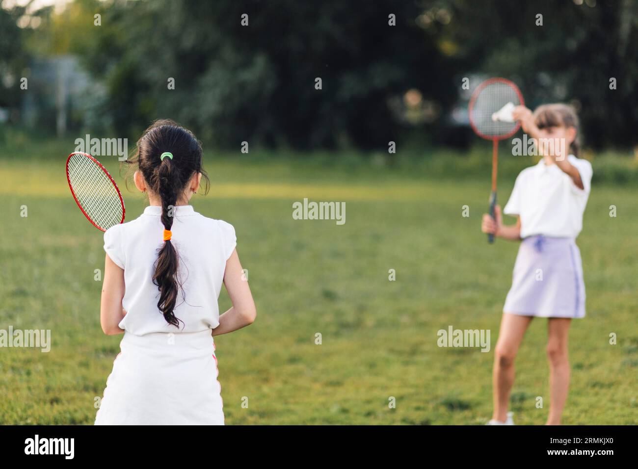 Rear view girl playing badminton with her friend Stock Photo - Alamy