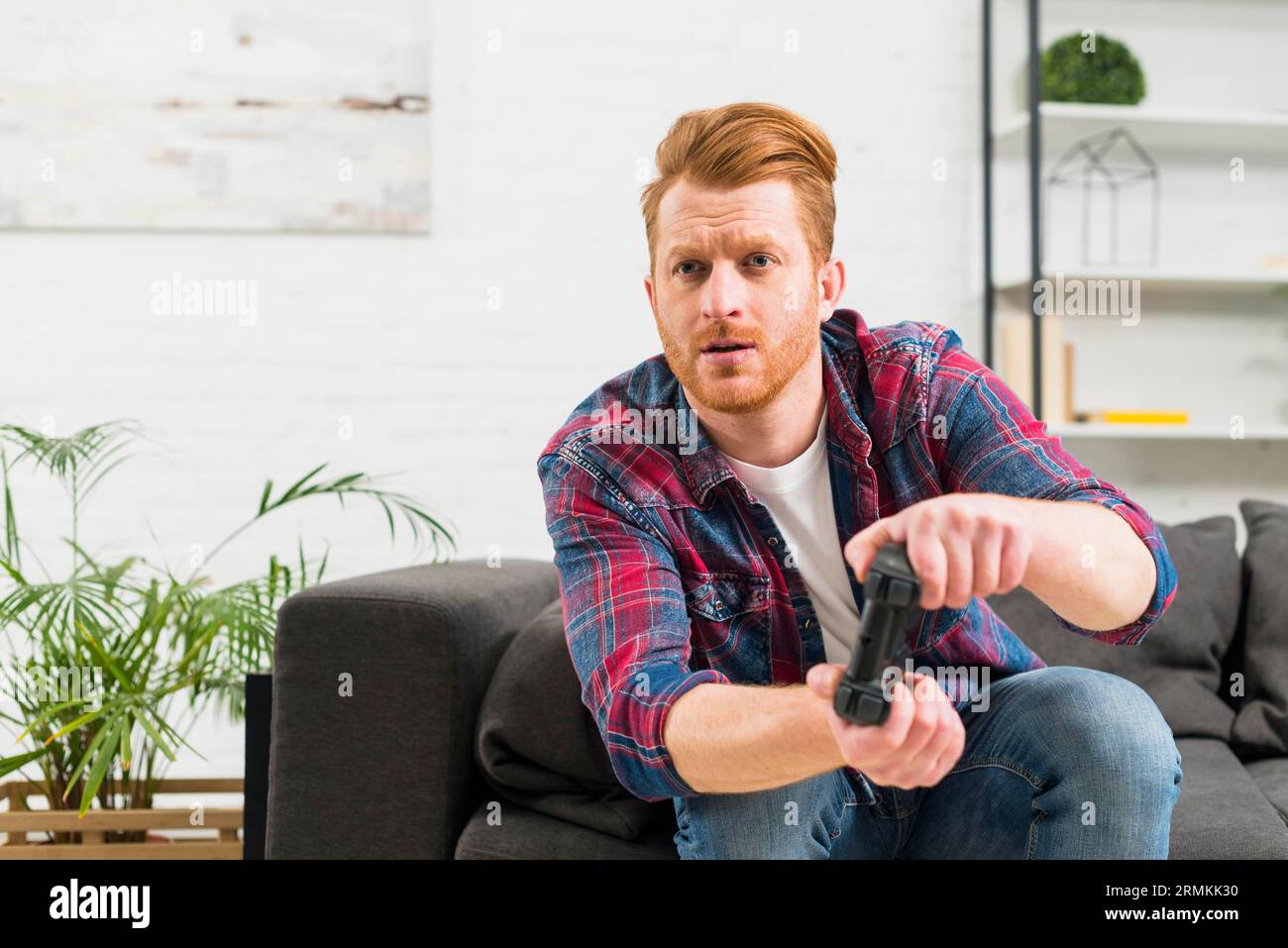 Serious young man playing video game home Stock Photo - Alamy