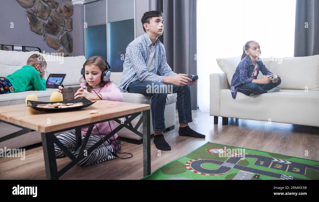 Sibling playing video games living room Stock Photo - Alamy