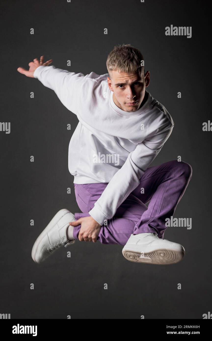 Side view male dancer purple jeans posing mid air Stock Photo - Alamy