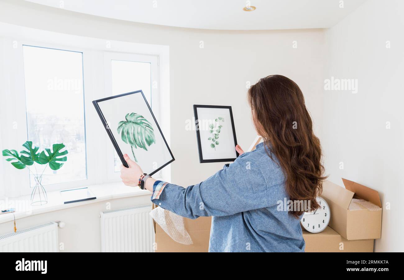 Side view young woman choosing picture frame her new home Stock Photo ...