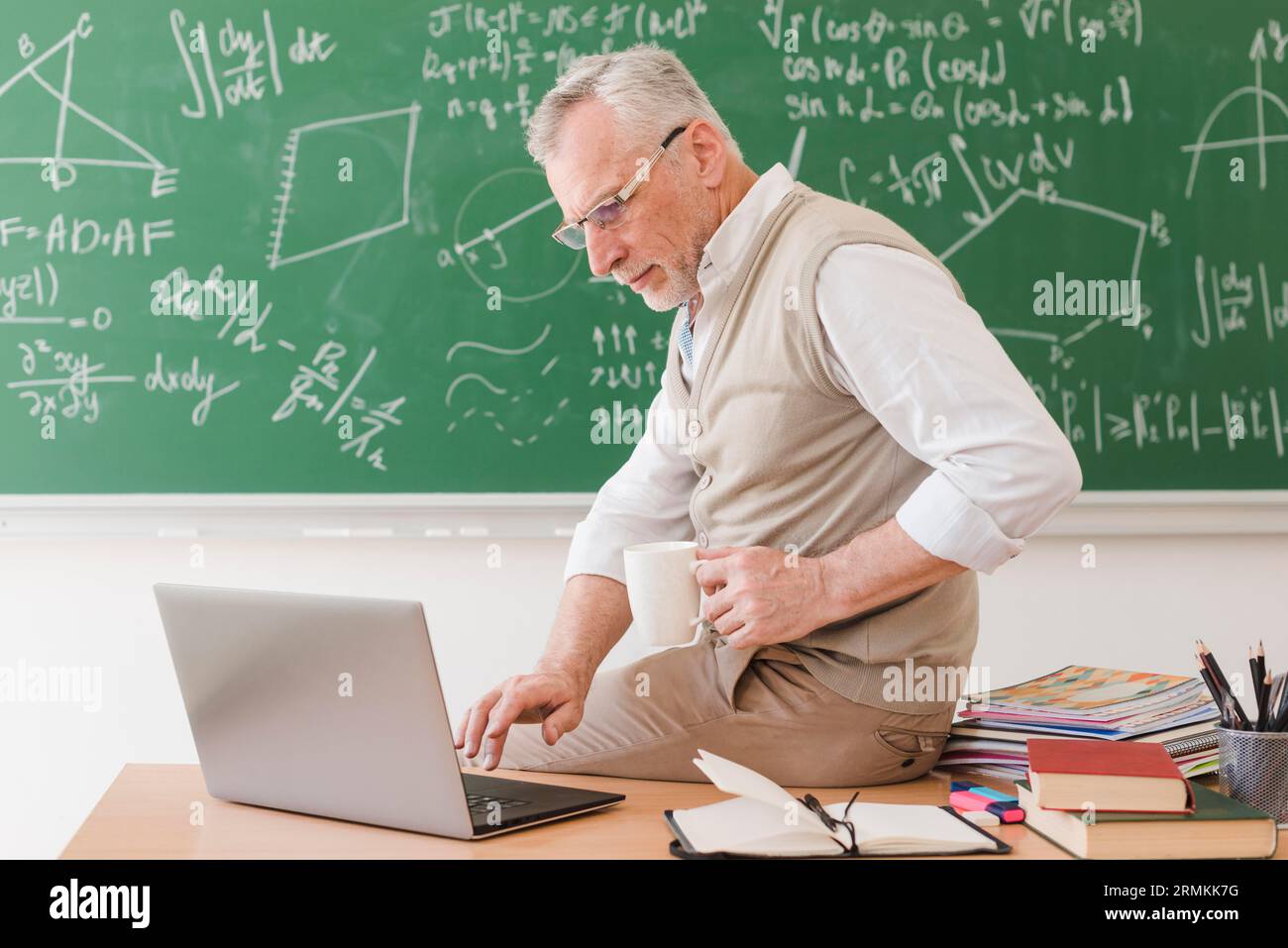 Senior professor sitting desk typing laptop Stock Photo - Alamy