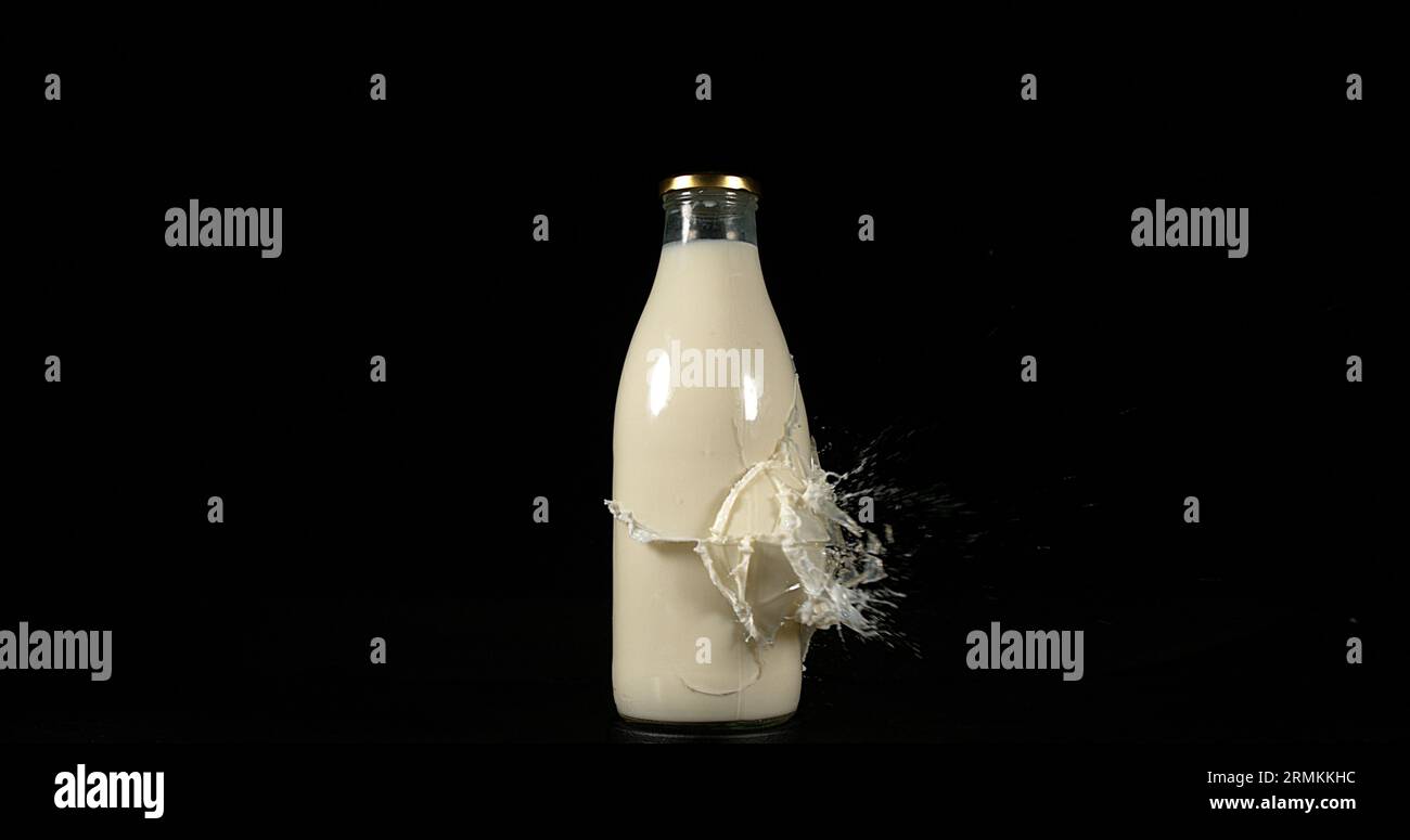 Bottle of Milk Exploding against Black Background Stock Photo - Alamy