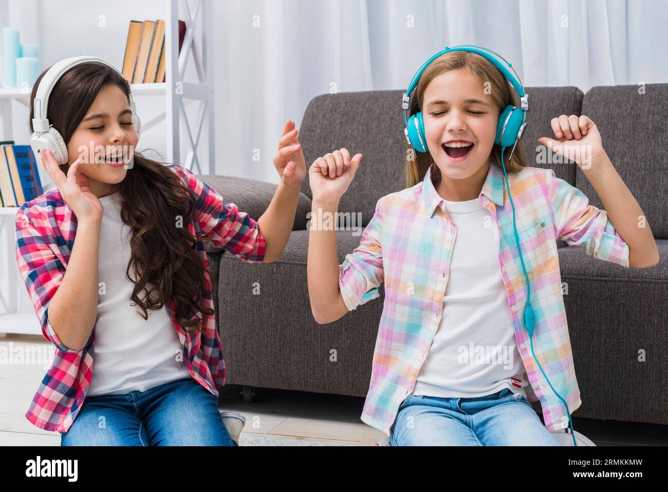 Two female friend enjoying music headphone home Stock Photo - Alamy