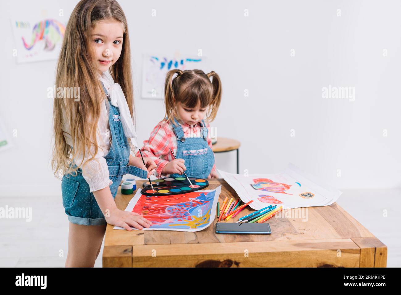 Two girls painting with aquarelle paper Stock Photo - Alamy