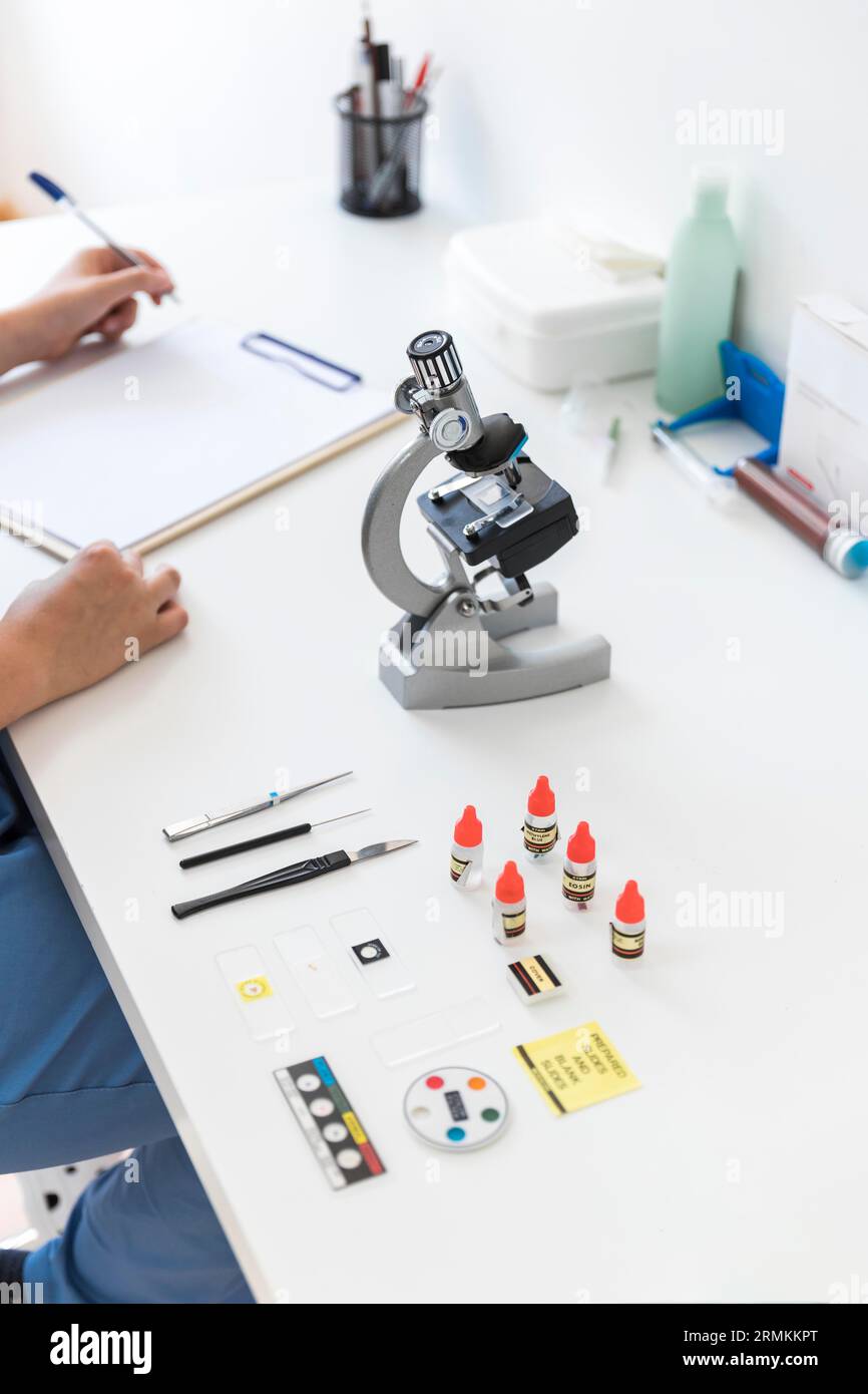 Veterinarian writing clipboard with microscope medical equipments ...