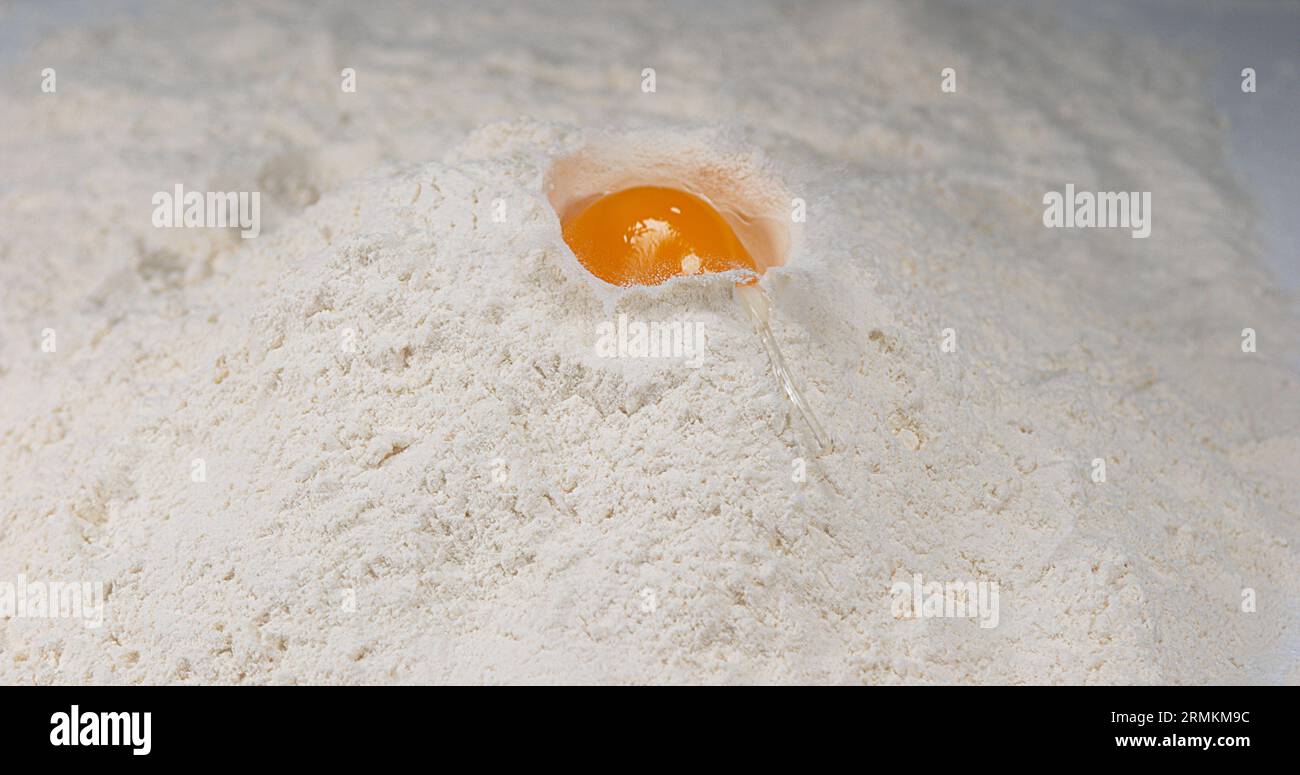 Egg Falling into Flour against White Background Stock Photo - Alamy