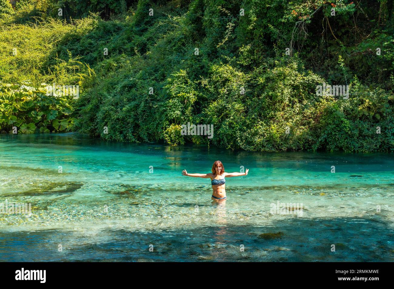 A tourist bathing smiling in the cold waters of the river of The Blue ...